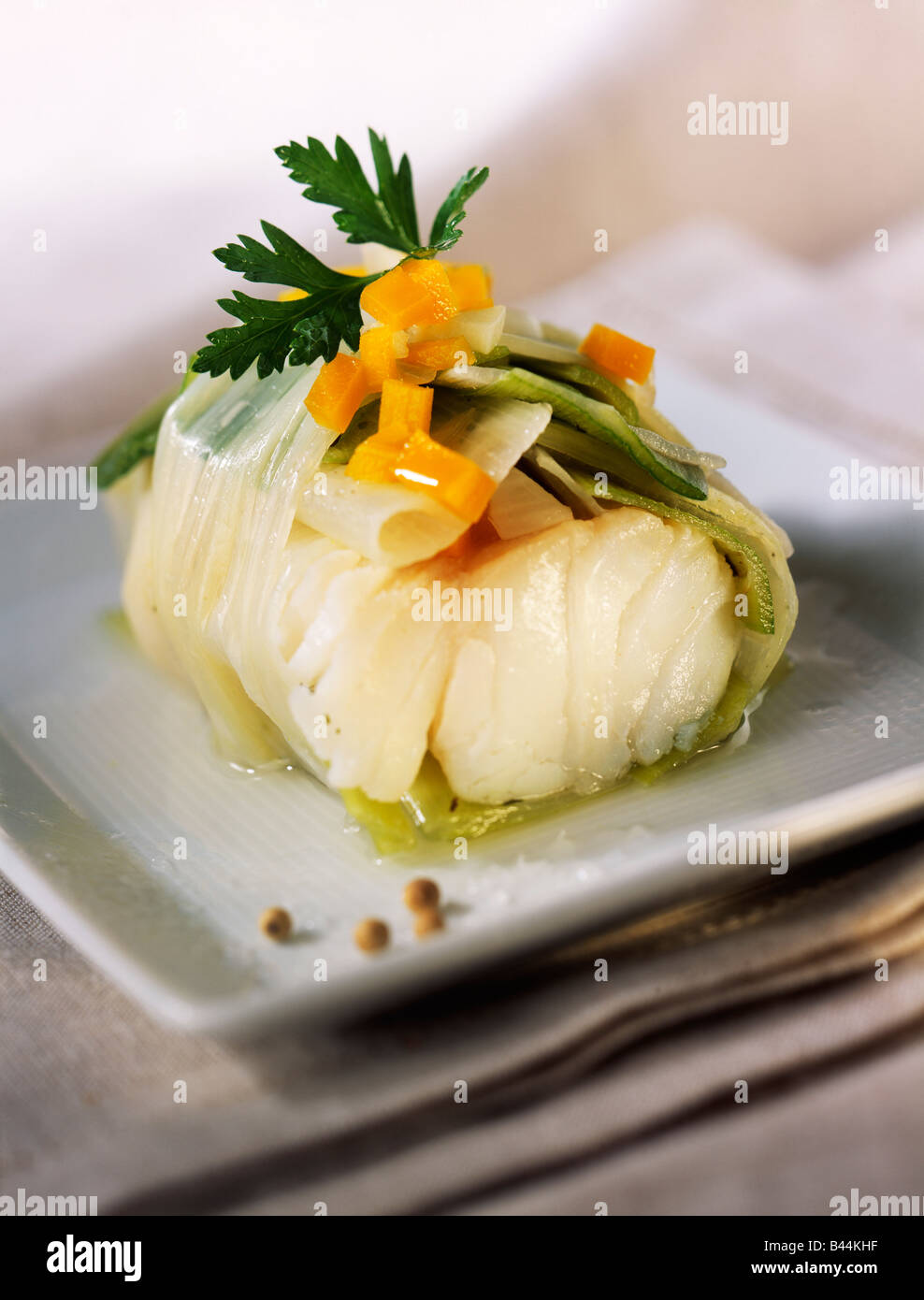Piece of cod wrapped in leeks Stock Photo - Alamy