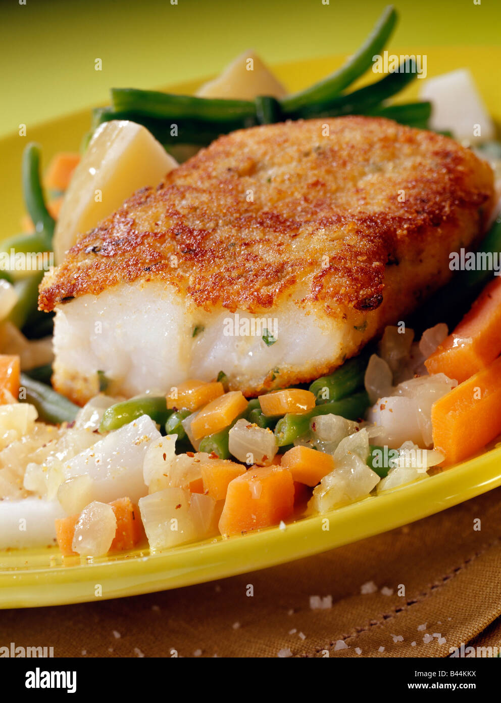 Breaded cod with young spring vegetables Stock Photo - Alamy