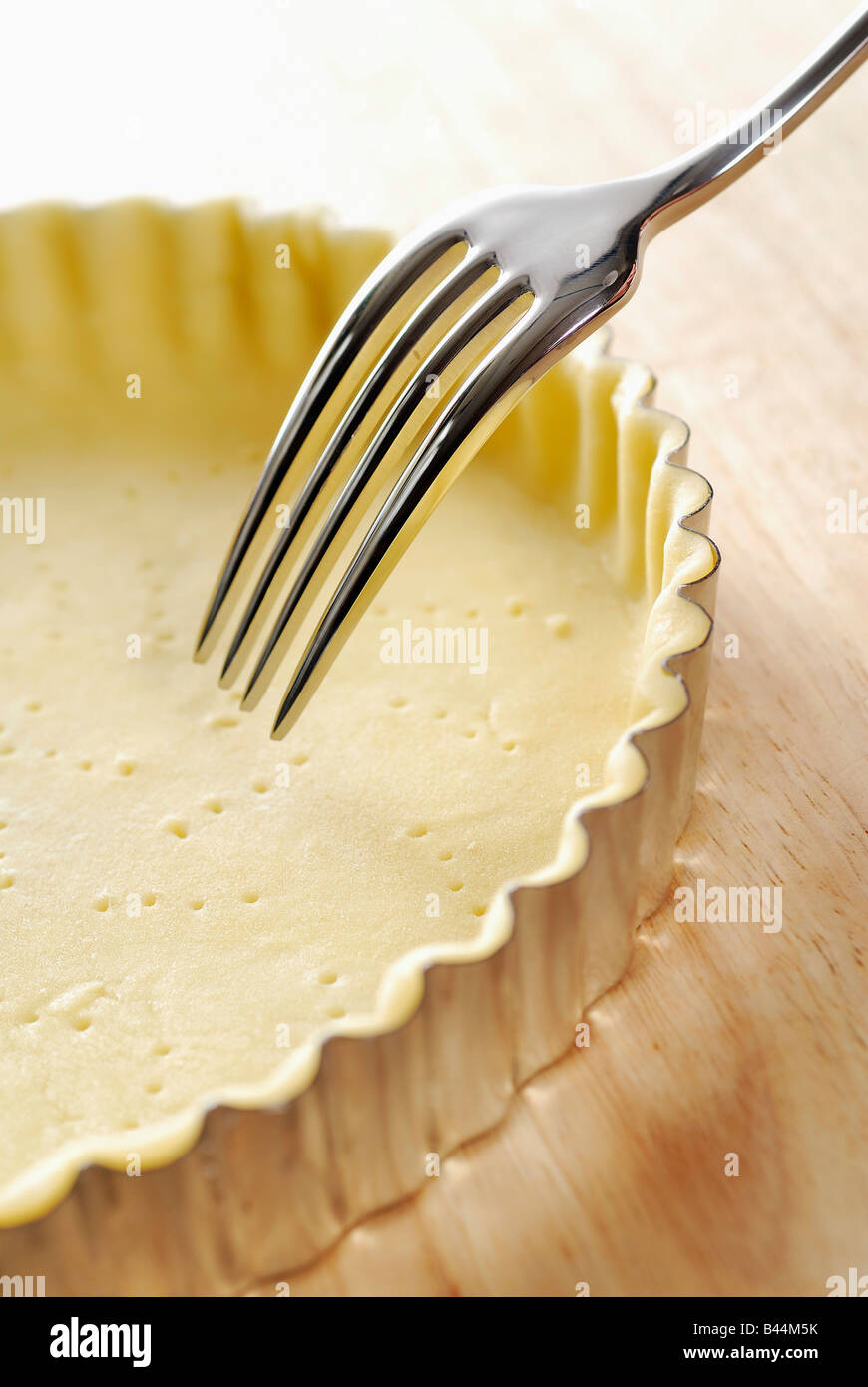 Pricking the pastry in the mould with a fork Stock Photo - Alamy