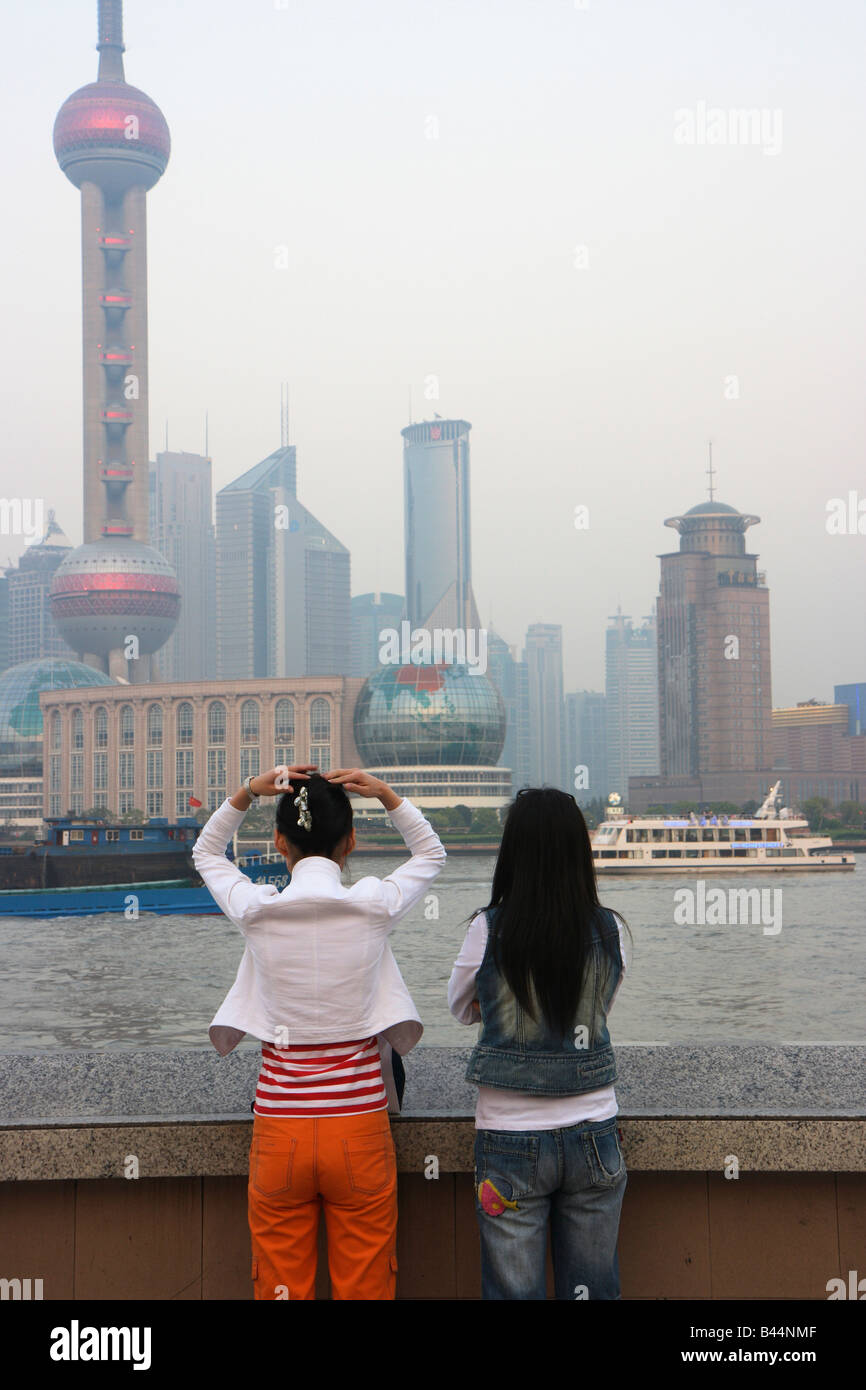 Two young women looking at the cityscape of Pudong in Shanghai, China ...