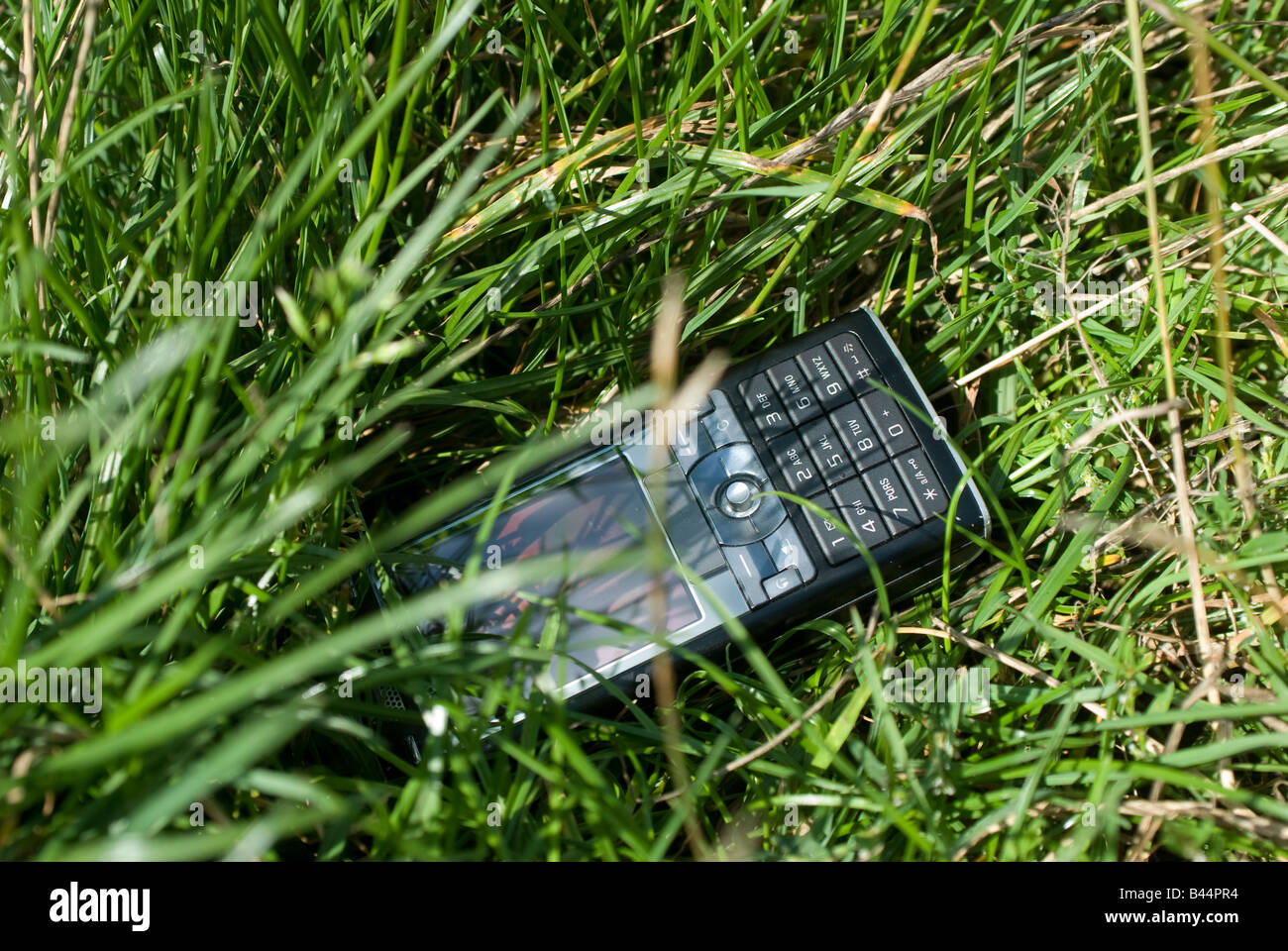Mobile phone dropped and lost in the grass in the uk countryside Stock ...