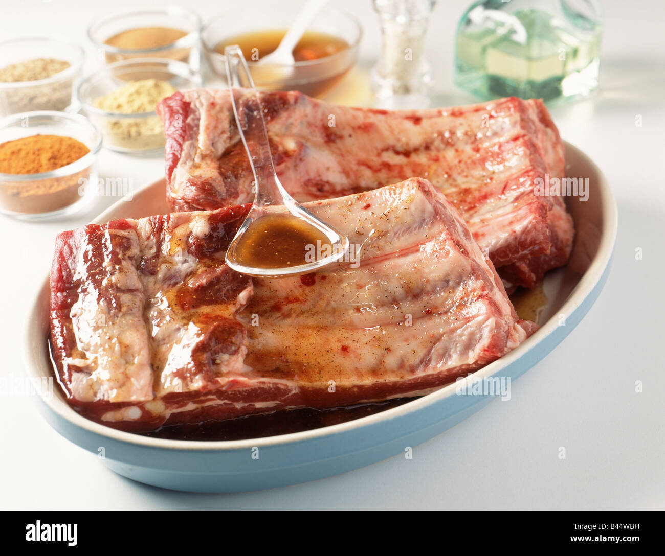 pouring marinade over spare ribs Stock Photo - Alamy