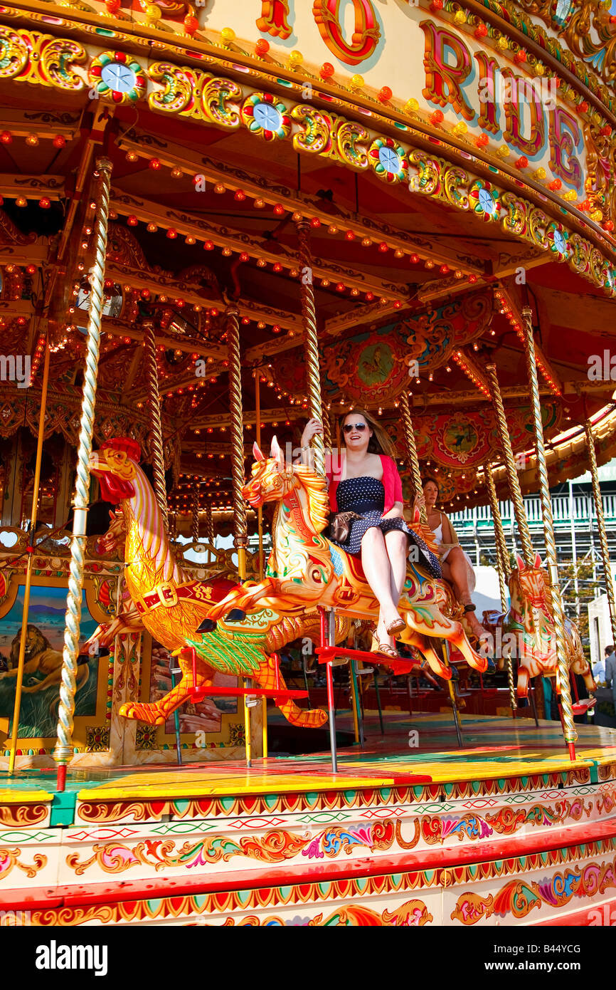 A young woman sitting side saddle on a horse on a carousel, Goodwood ...