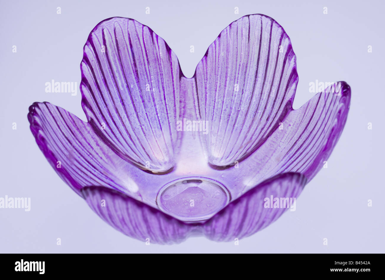 Pretty lilac coloured glass bowl in the shape of a flower on a pale ...