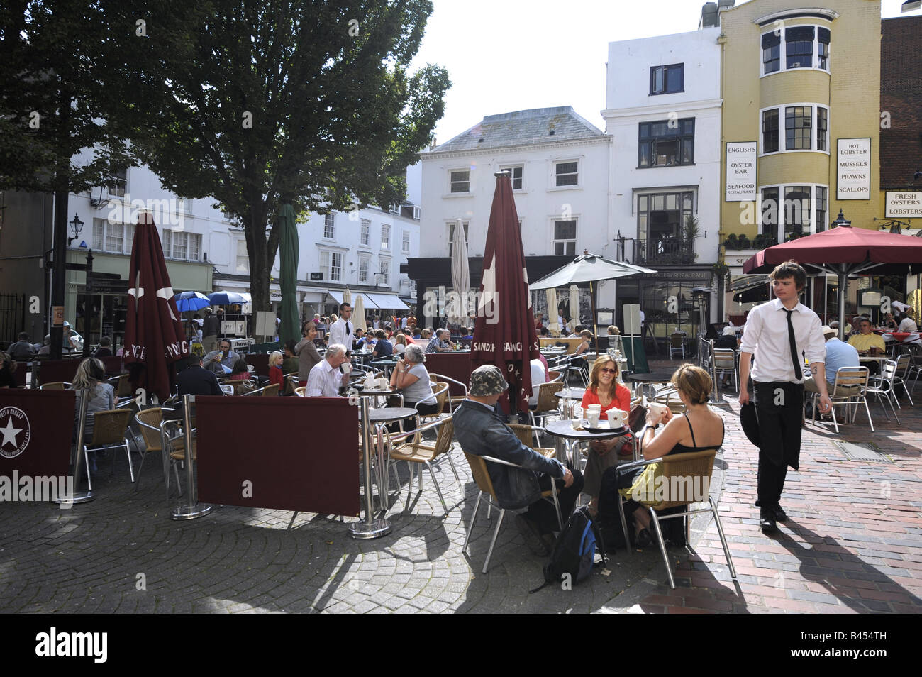 Visitors eating and drinking at pavement cafes and restaurants in ...