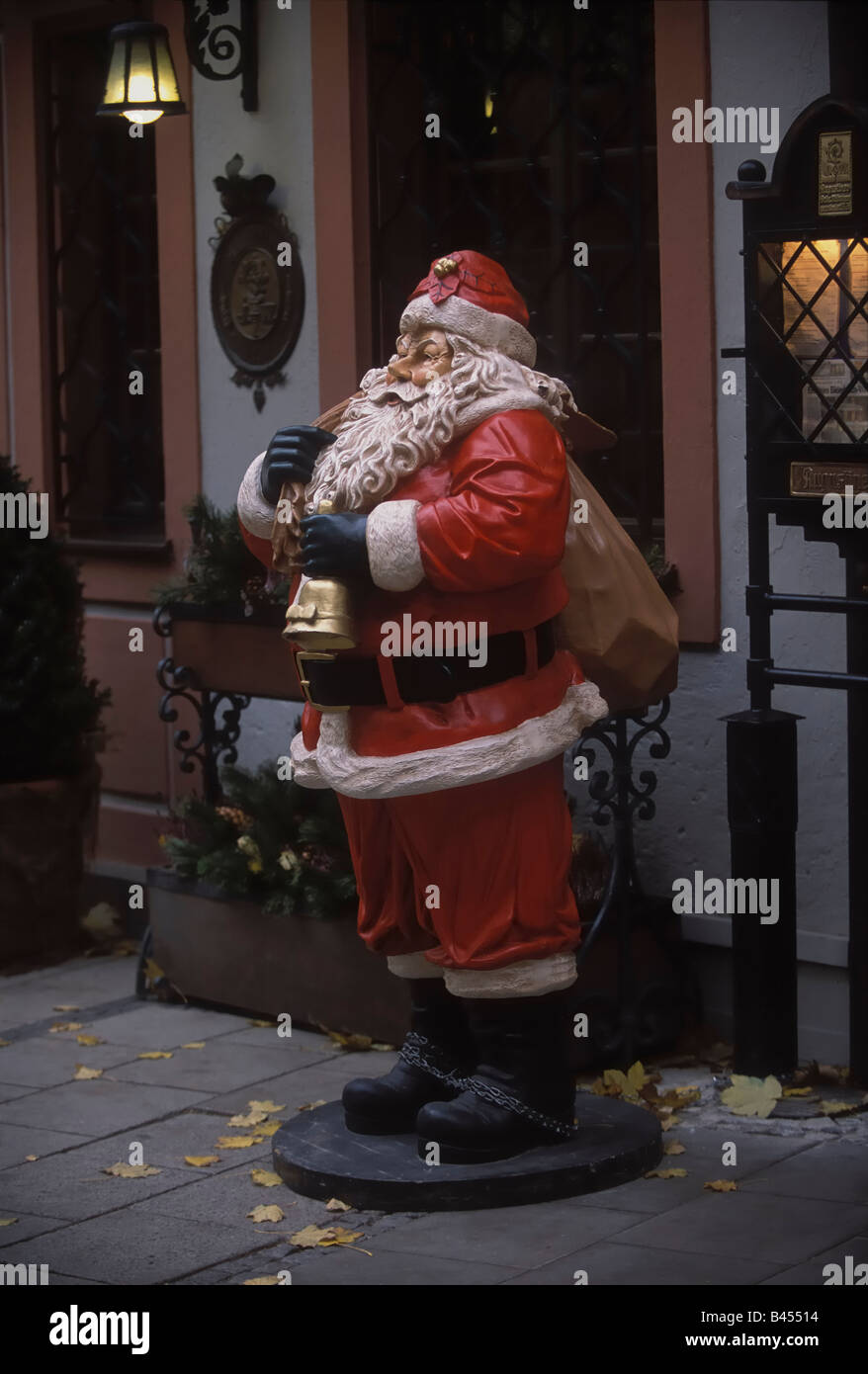 Christmas Santa kris kringle statue standing on street with bell Stock ...