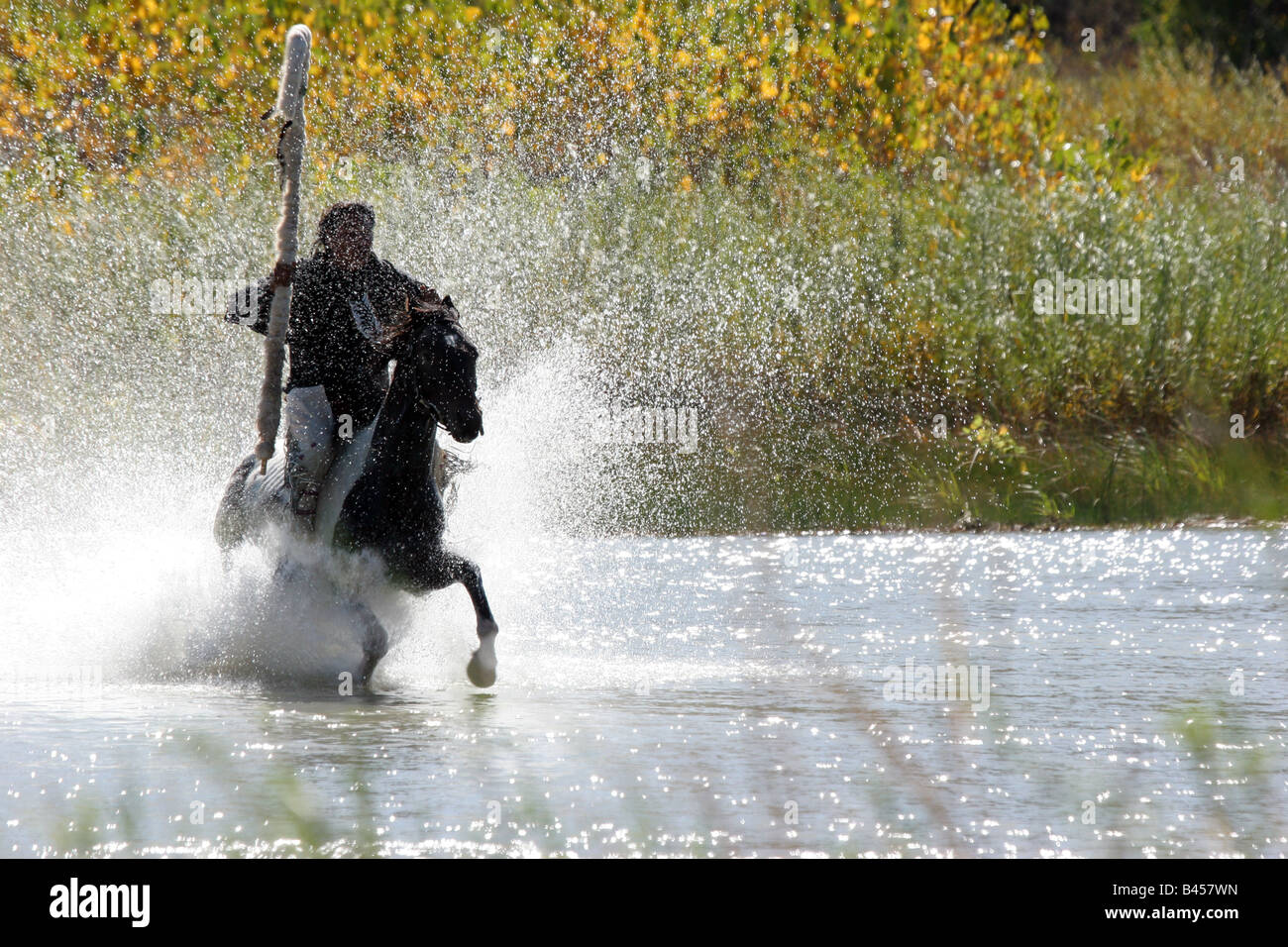 A Native American Sioux Indian on horseback riding across a river on ...