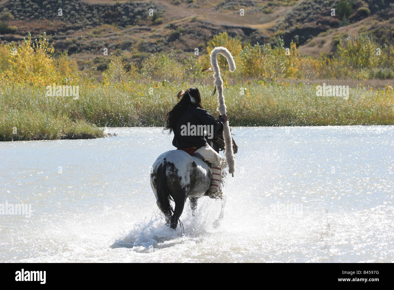A Native American Sioux Indian on horseback riding his pony with a ...