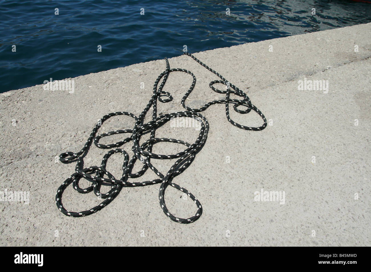 coil of tangled boat mooring rope in harbour Stock Photo - Alamy