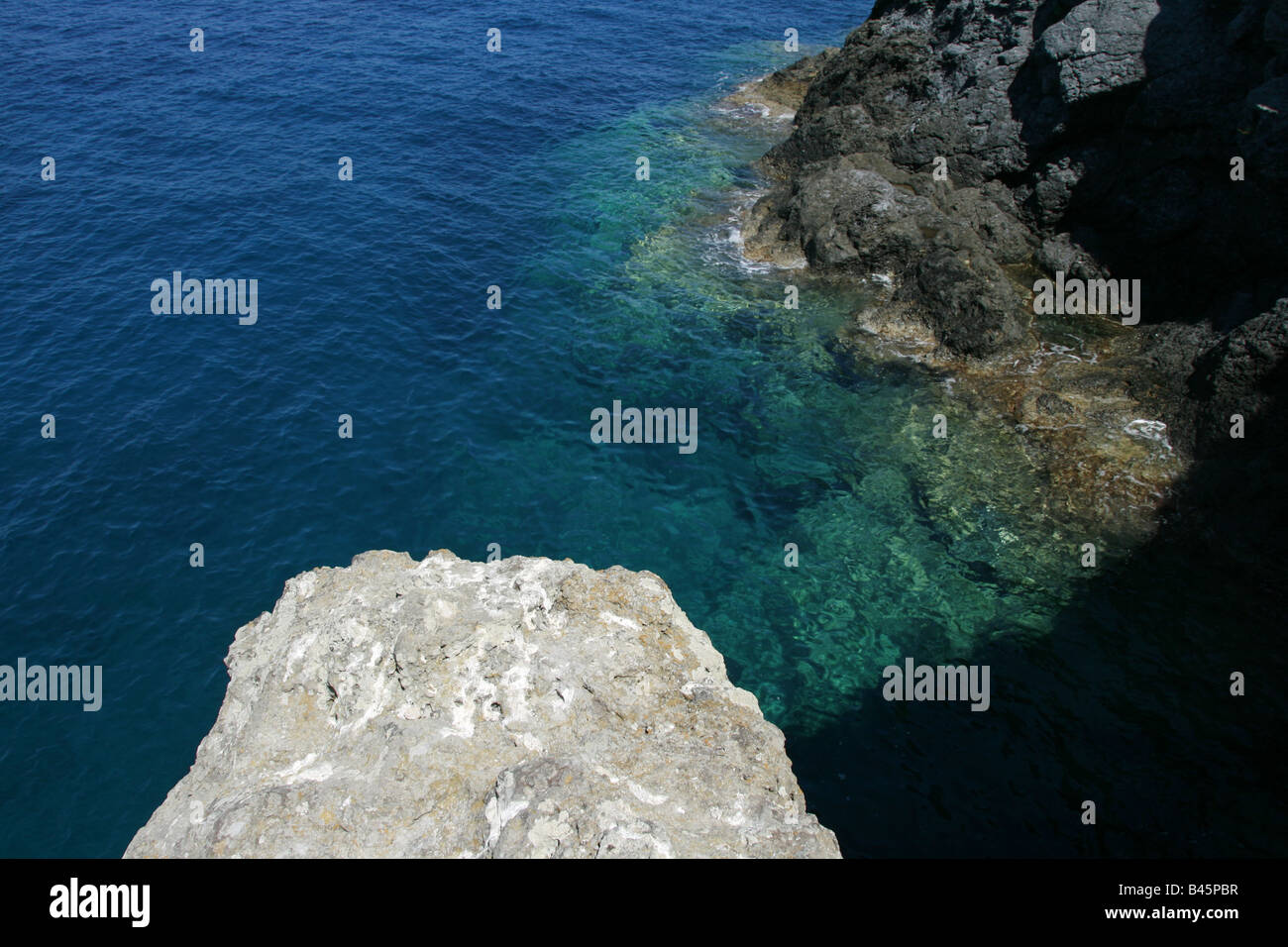 ne wild rocky ledge over calm sea waves Stock Photo - Alamy