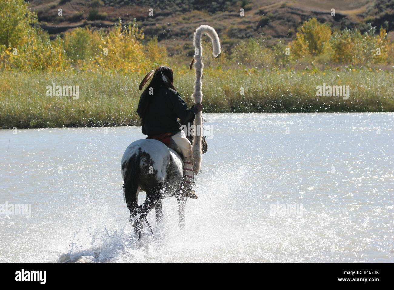A Native American Sioux Indian on horseback riding his pony across a ...