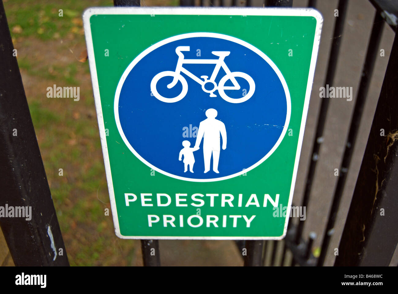 green and blue sign indicating pedestrian priority over cyclists on ...