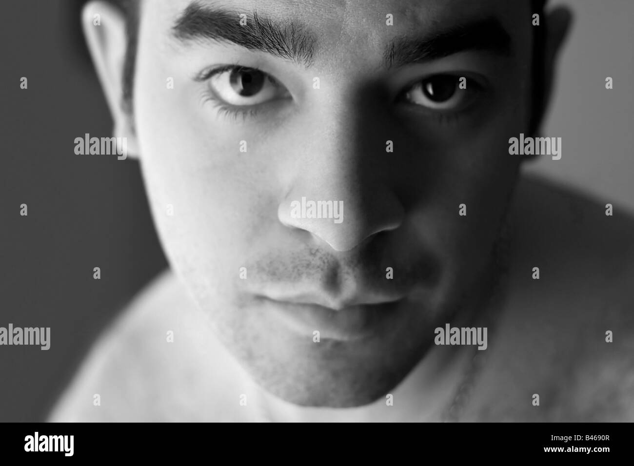 A portrait of a young man with a serious or concerned look on his face ...