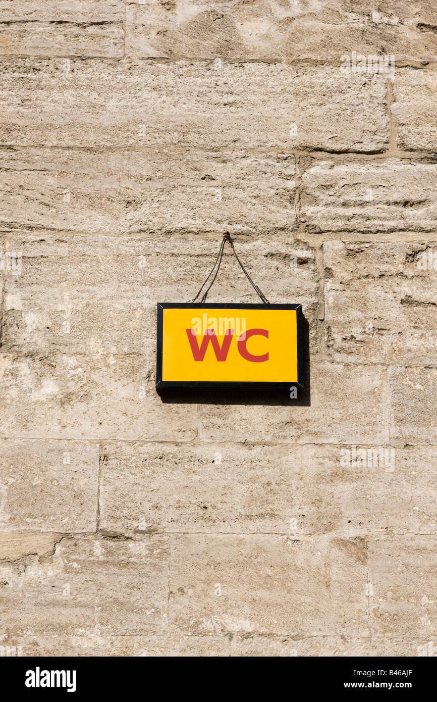 yellow wc sign hanging on wall Stock Photo - Alamy