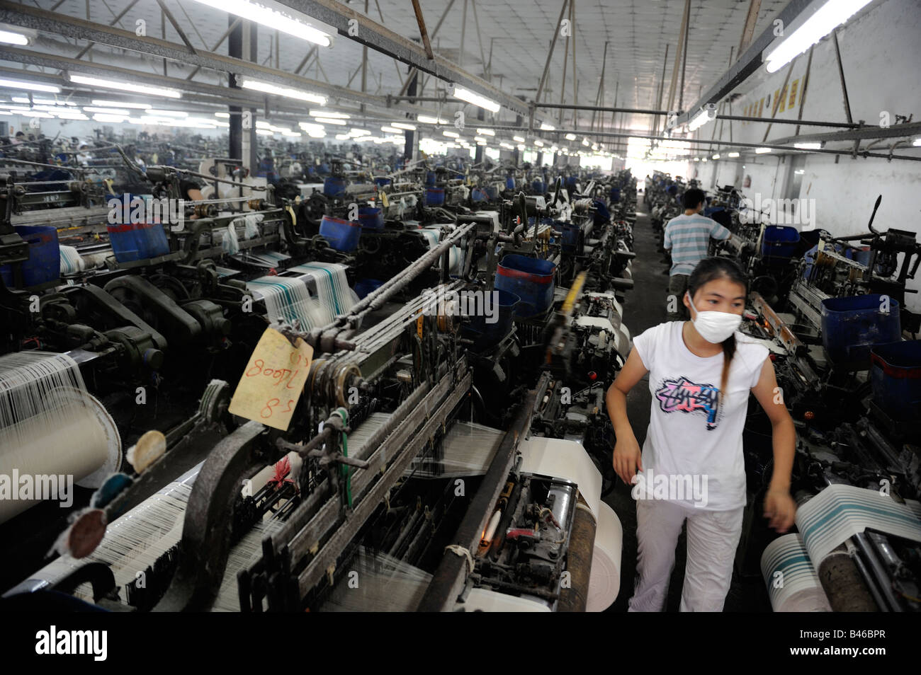 Female worker operating machine at a textile factory in Dongguan ...