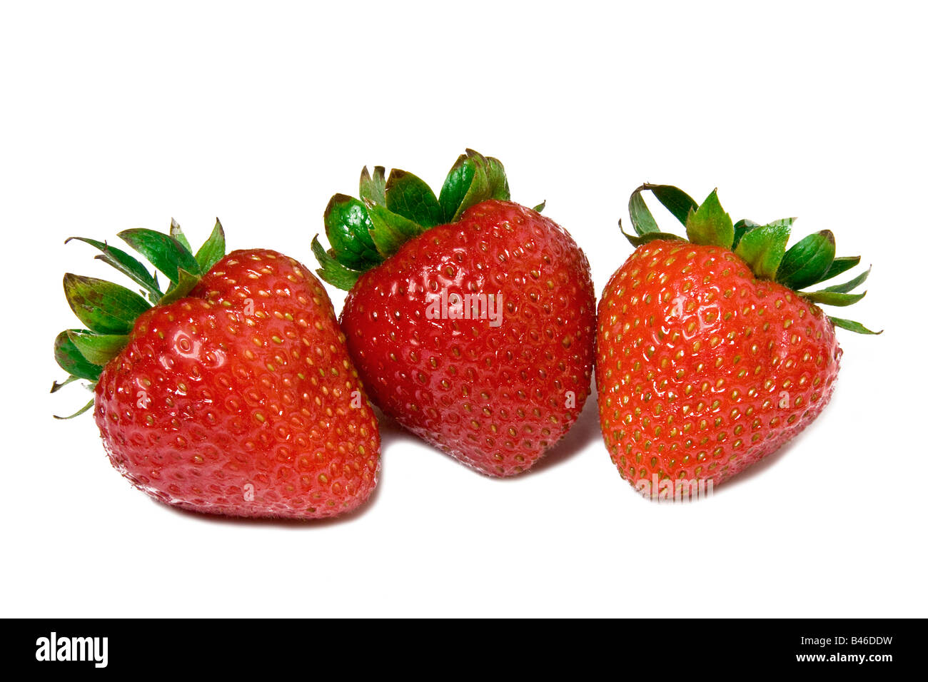 Three strawberries on a white background Stock Photo - Alamy