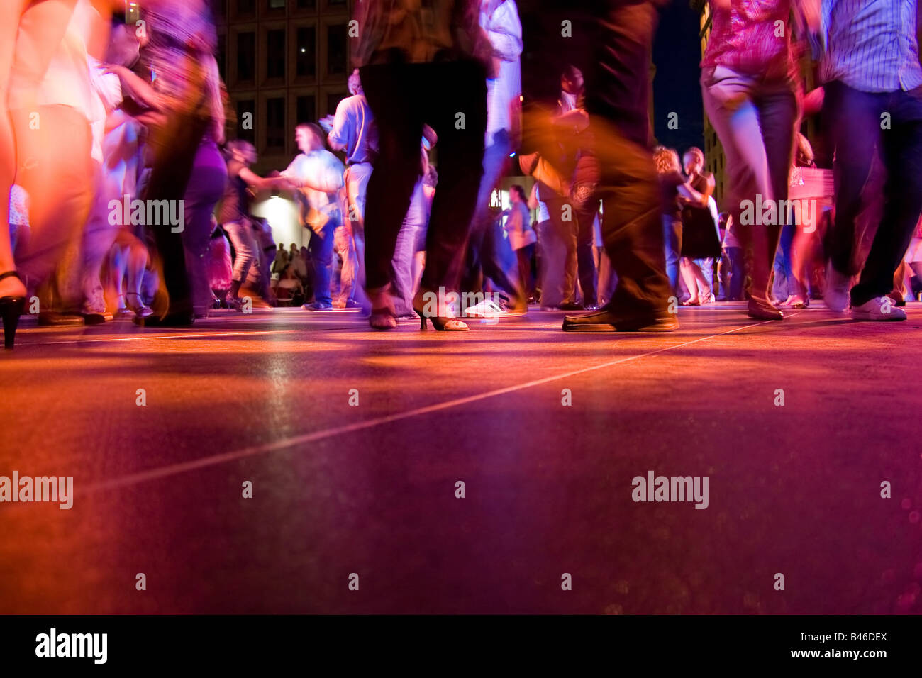 A low shot of the dance floor with people dancing under the colorful ...