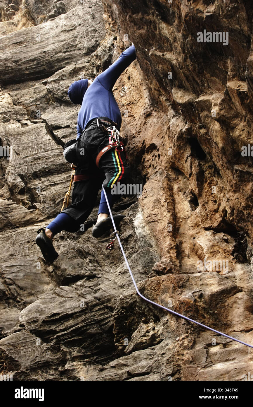 Rock climber making his way up a vertical cliff wall Nepal Stock Photo ...