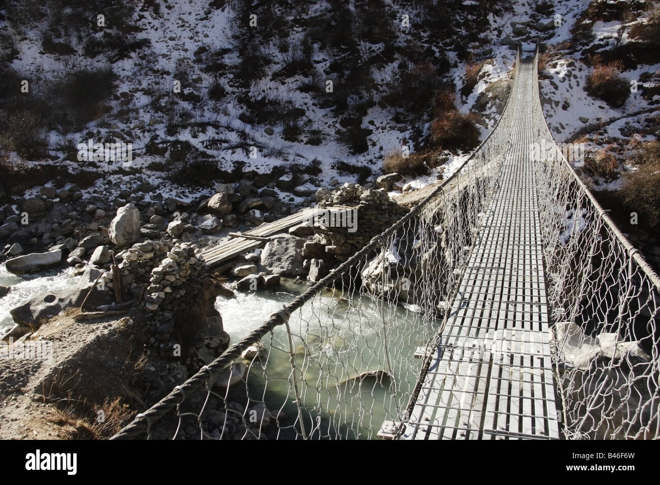 New metal and old Tibetan cantilever wood bridge crossing the Langtang ...