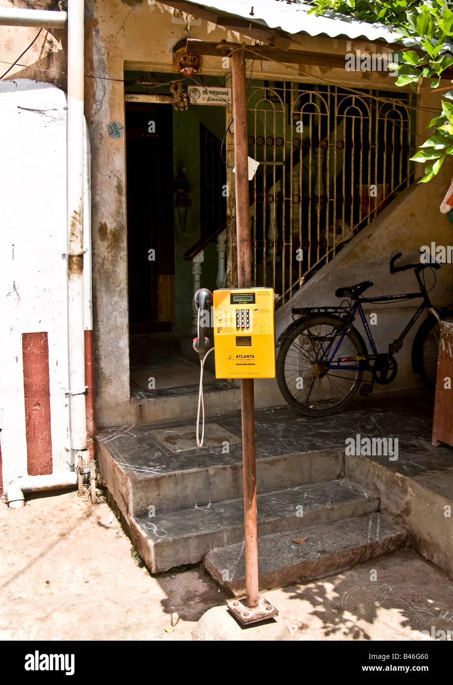 Public telephone mounted on metal pipe support of roof shed and a ...