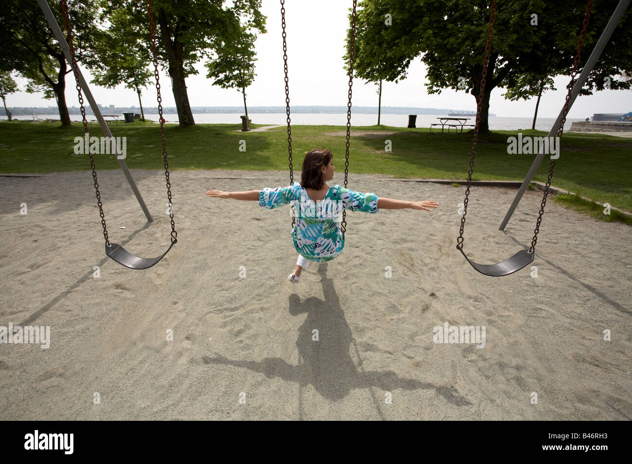 Woman Sitting on Swing Stock Photo - Alamy