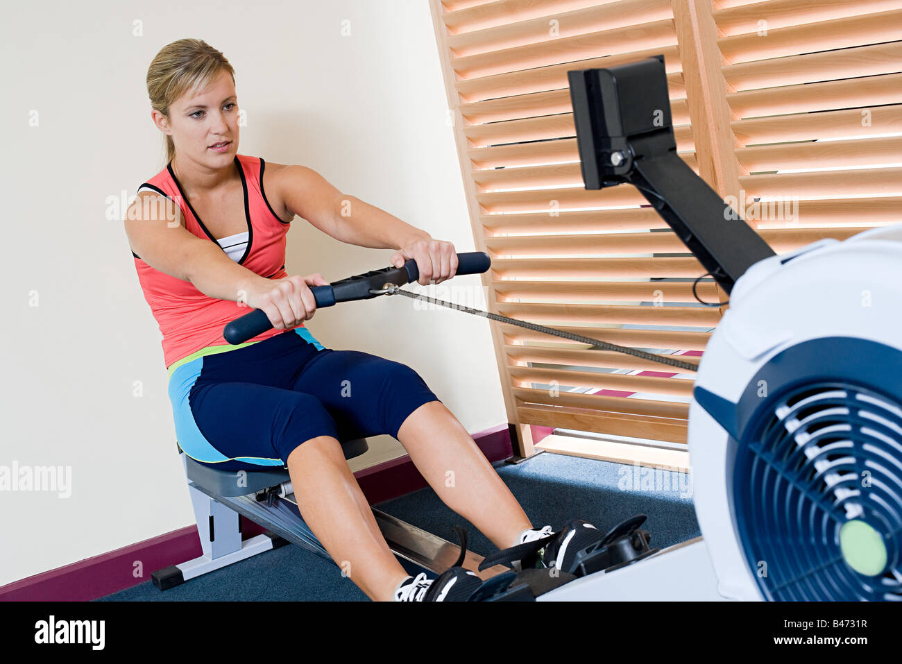 Woman on rowing machine Stock Photo - Alamy