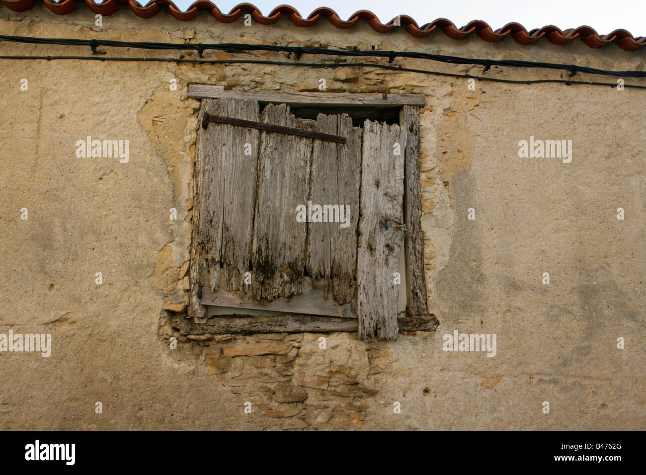 decaying wooden shuttered window in crumbling old stone building Stock ...