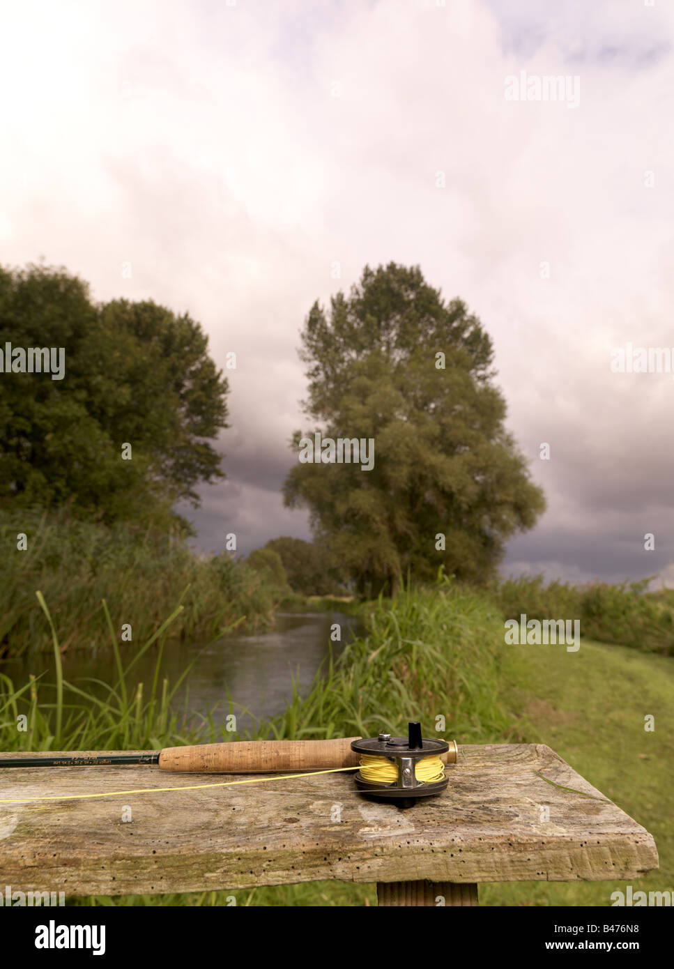 Fly fishing rod and reel on a bench seat beside the River Test ...