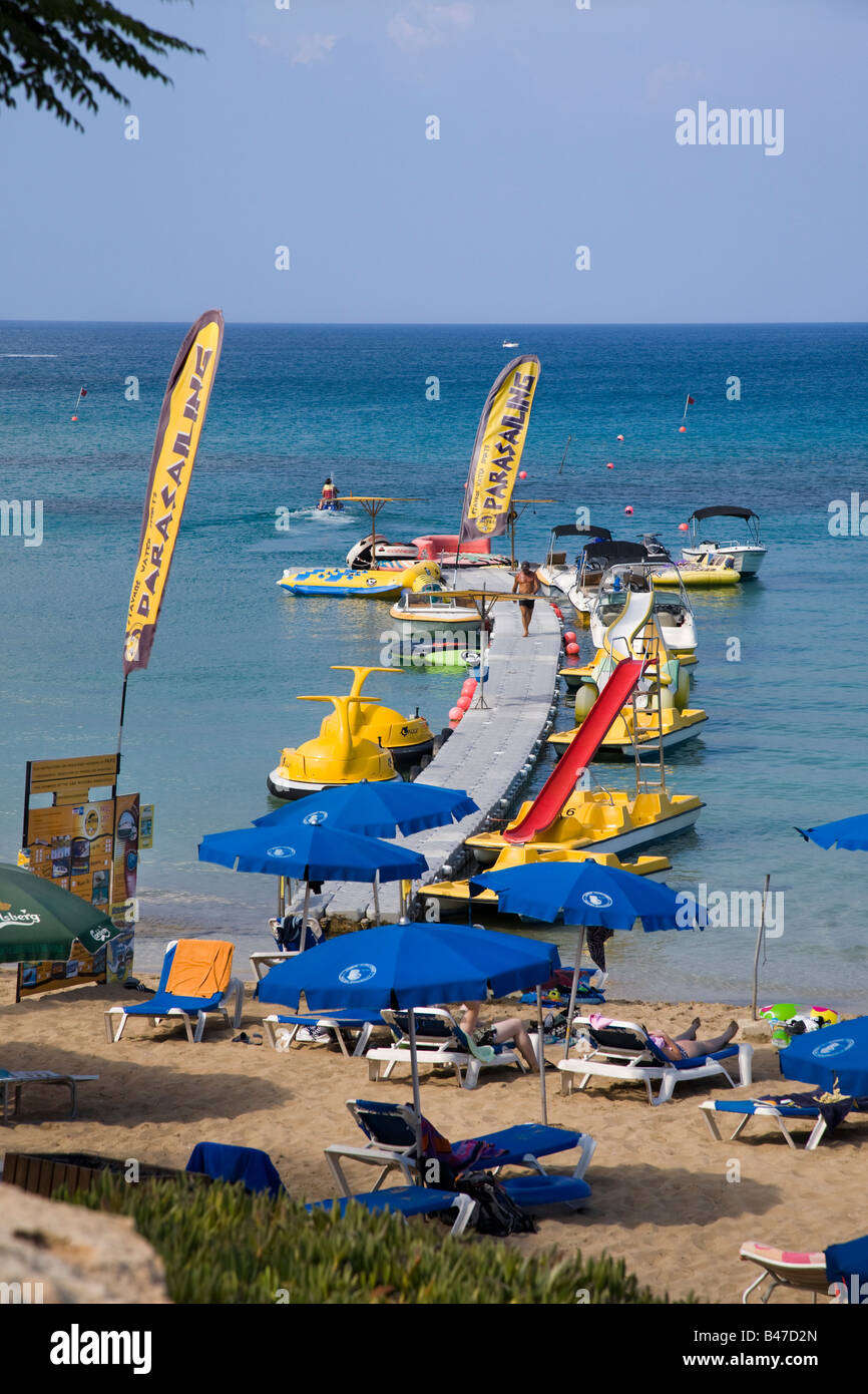 VIEW OF FIG TREE BAY, PROTARAS, IN CYPRUS WITH MANY BLUE UMBRELLAS AND ...