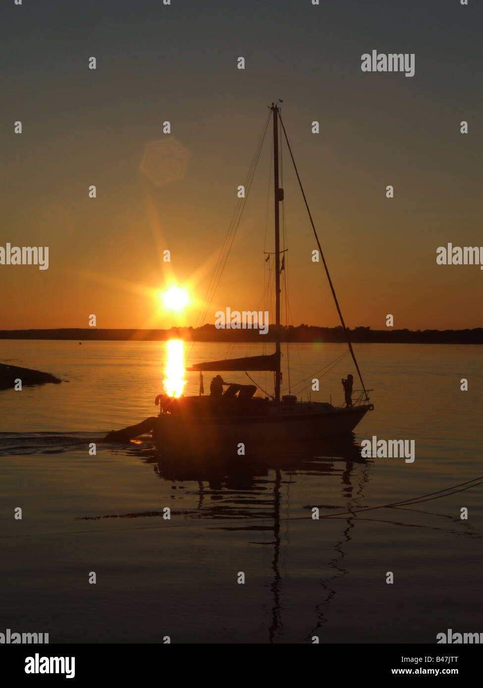 one single sailing boat in sea at sunset Stock Photo - Alamy