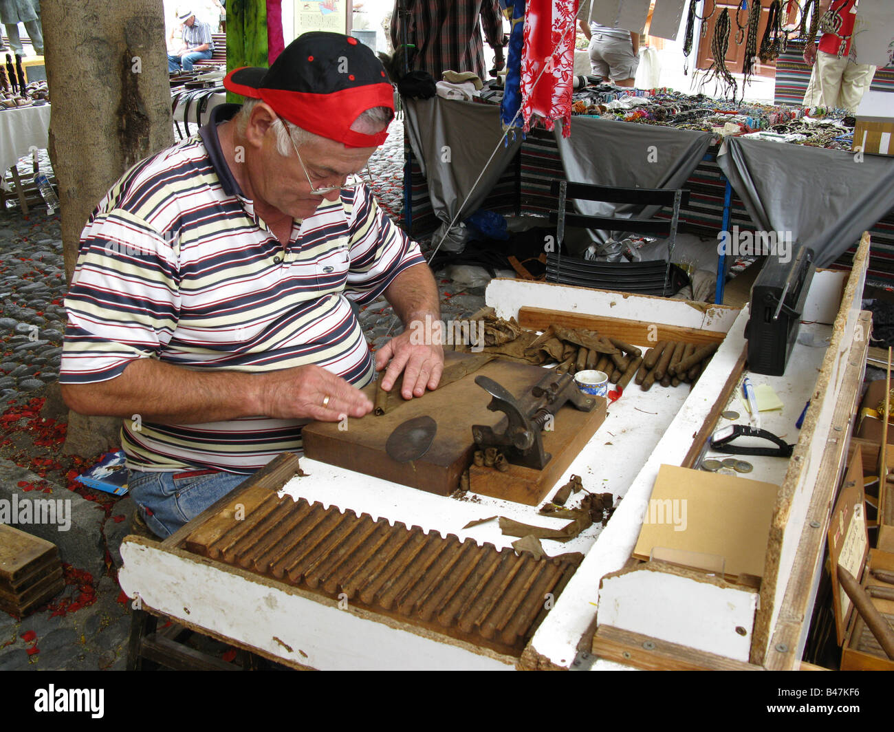 Man hand rolling a cigar on a market stall at Plaza Vandale, Santa Cruz ...