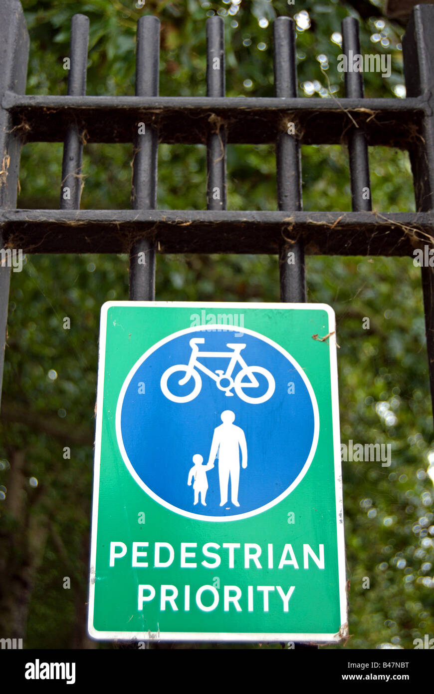 green and blue sign indicating pedestrian priority over cyclists on ...