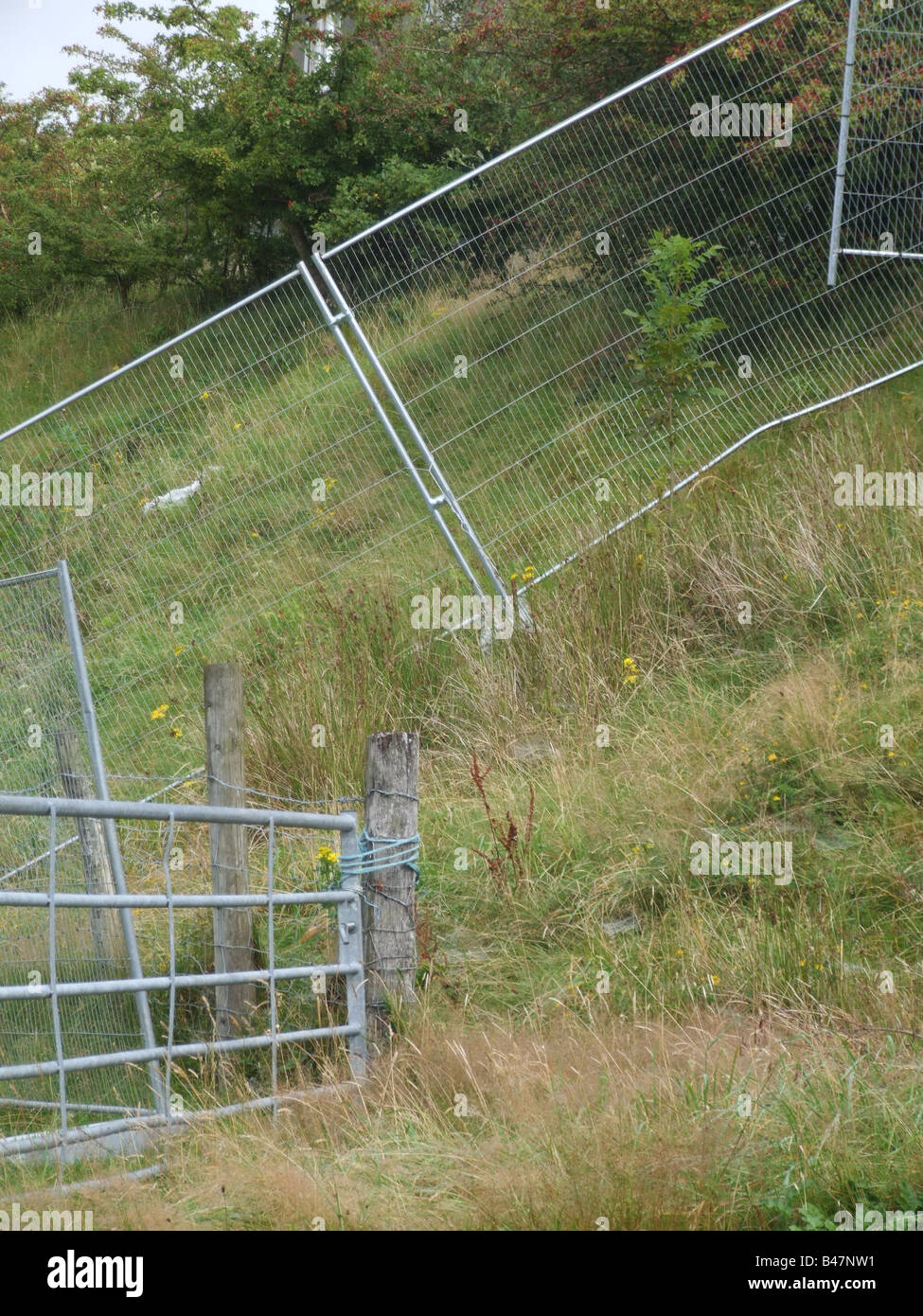 high fence barrier on hill in field in countryside Stock Photo - Alamy