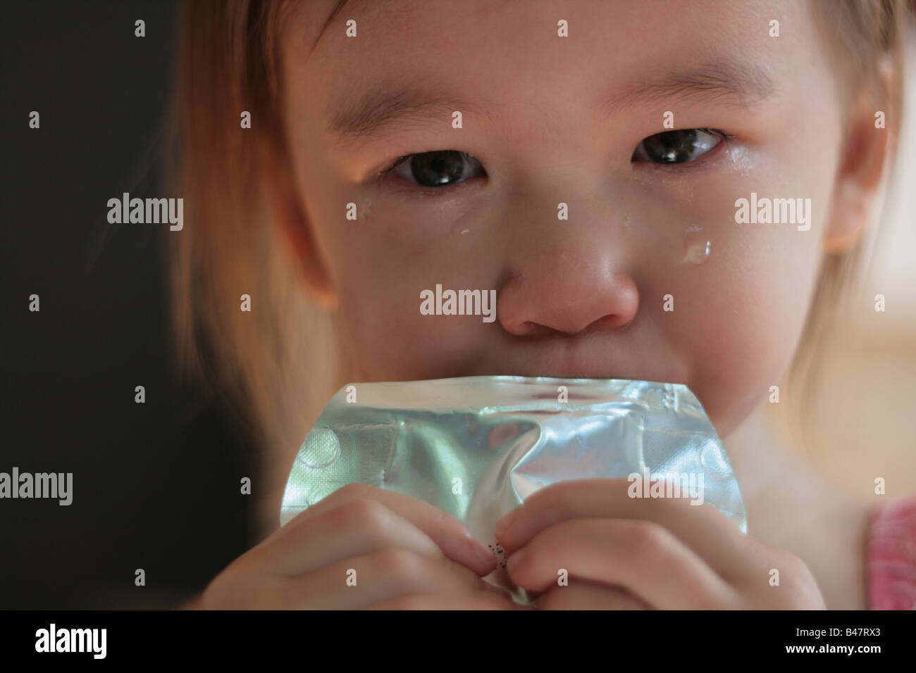 A 20-month-old toddler, who has been crying, drinks some juice from a ...