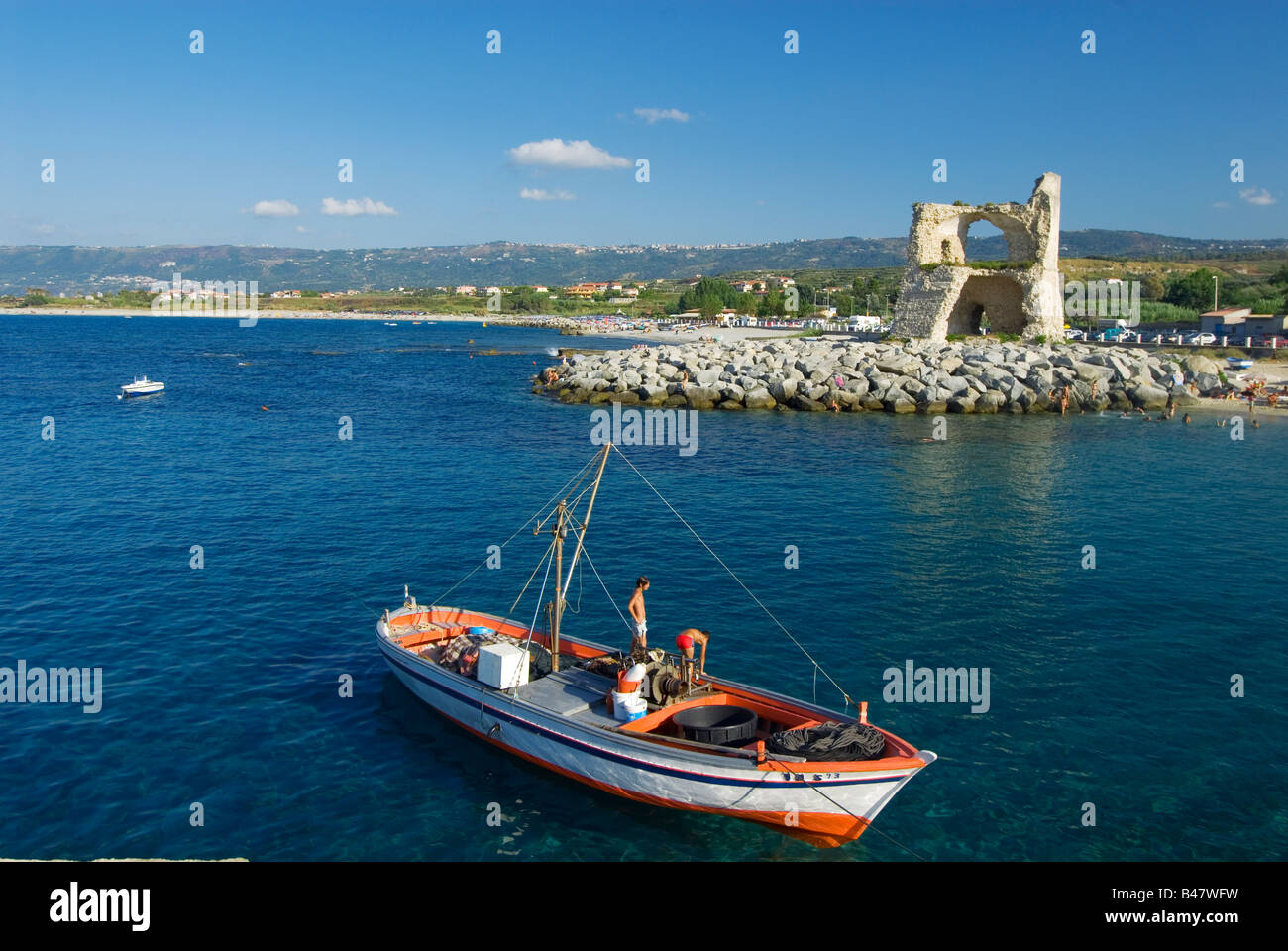 Italian boys playing on a fishing boat off the beach in Briatico ...