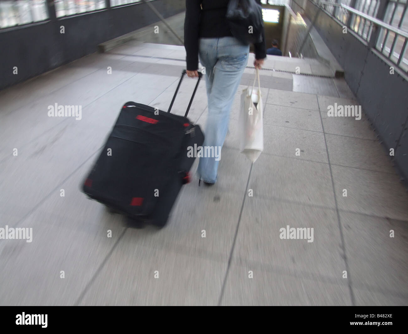 person pulling heavy trolley case in town Stock Photo - Alamy