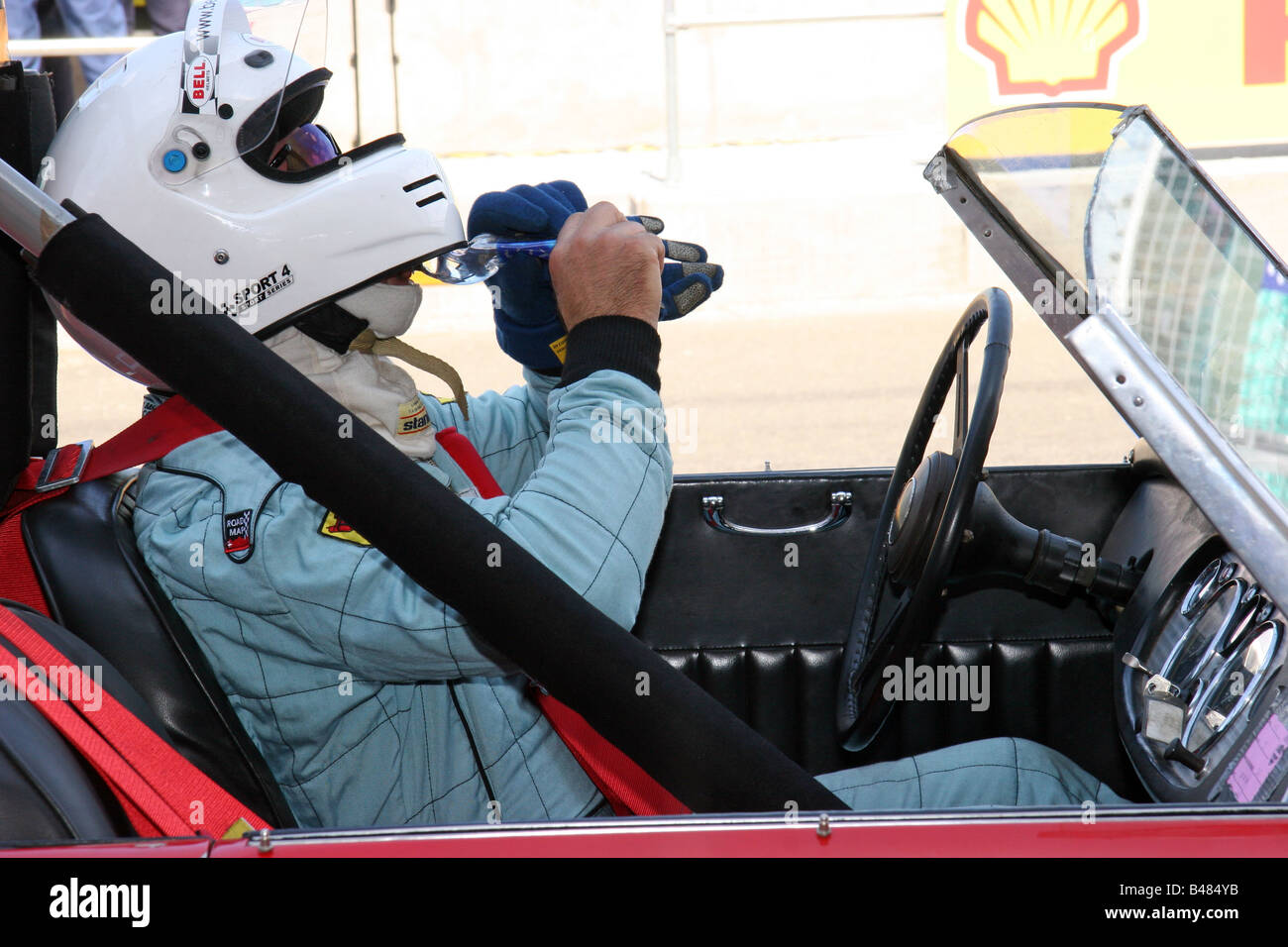 classic red racing car with the driver drink before the race still ...