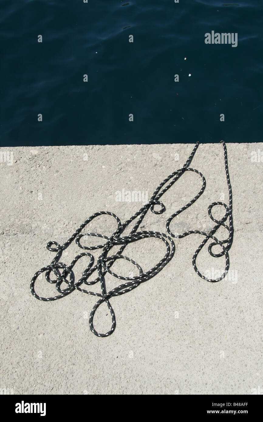 coil of tangled boat mooring rope in harbour Stock Photo - Alamy