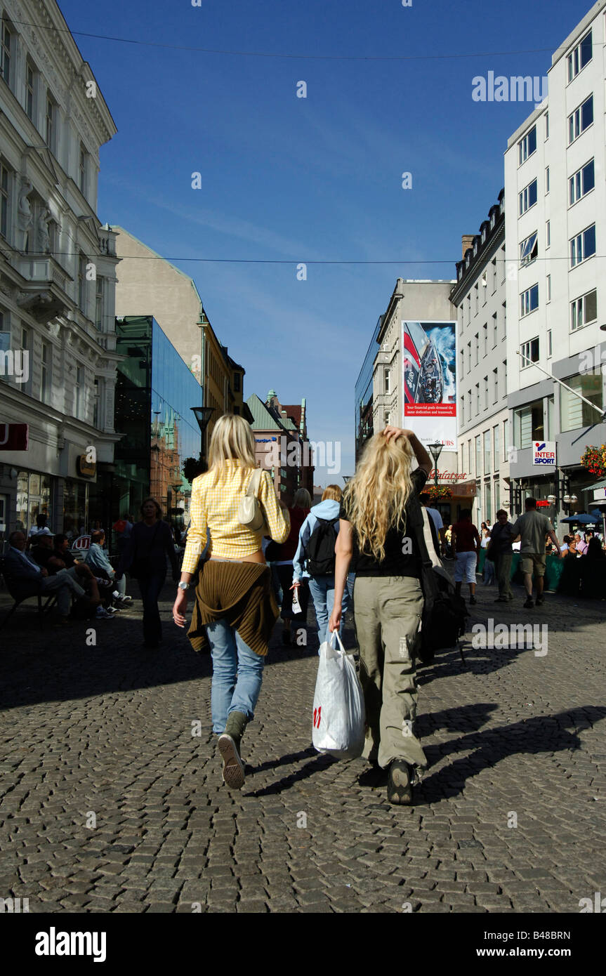Two scruffily dressed young blond women walking down a pedestrian ...