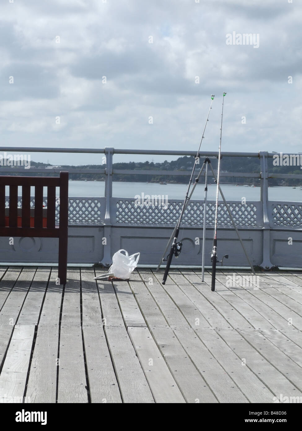 two fishing rods left on pier in bangor wales Stock Photo - Alamy