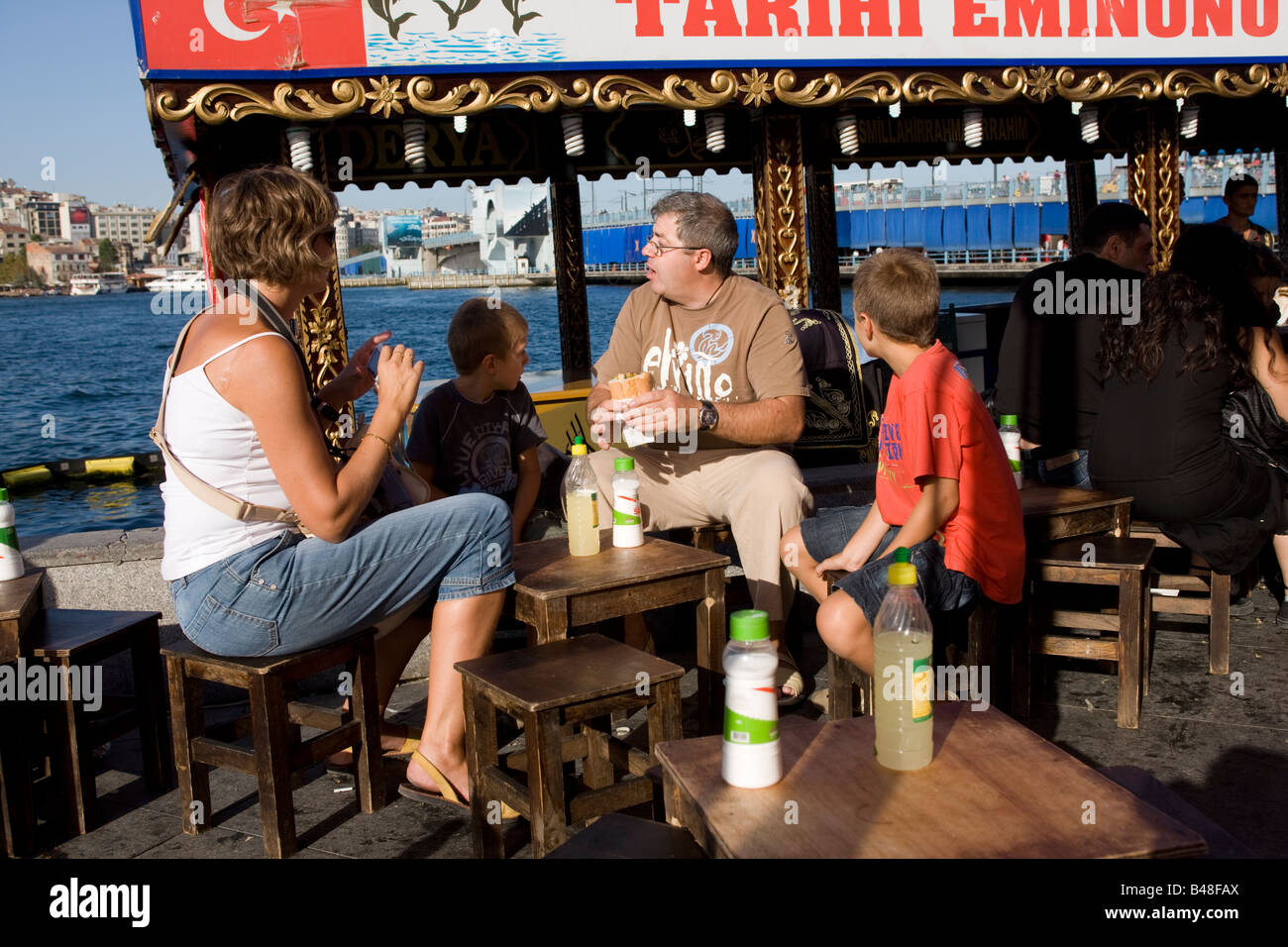 Family eating Fish Sandwich Balik Ekmek at Eminou Harbourside Istanbul ...
