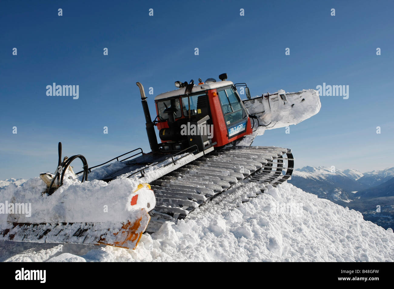snow cat plowing snow to build a snowboard jump Stock Photo - Alamy