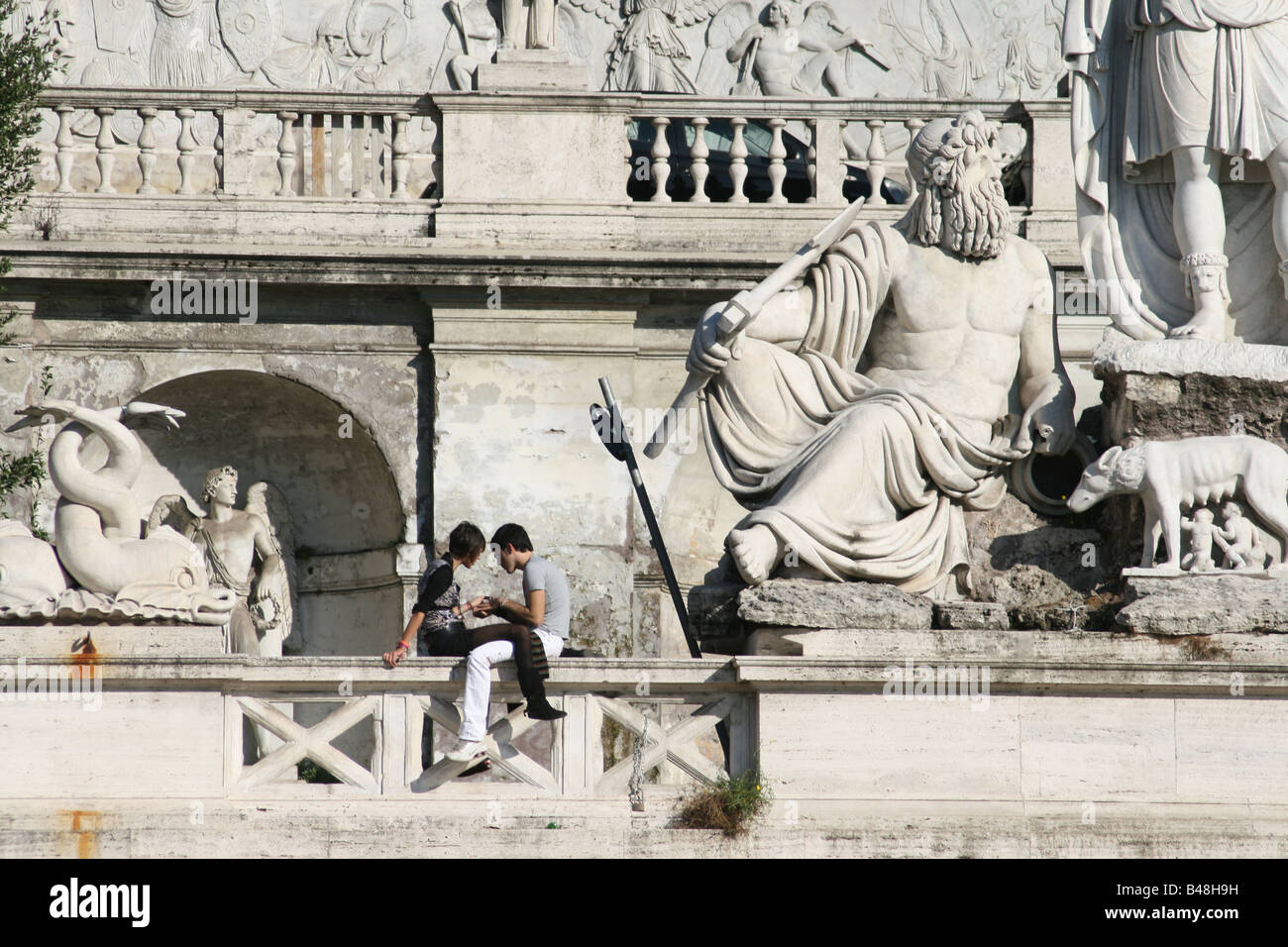 young couple sitting on wall, piazza del popolo square, rome Stock ...
