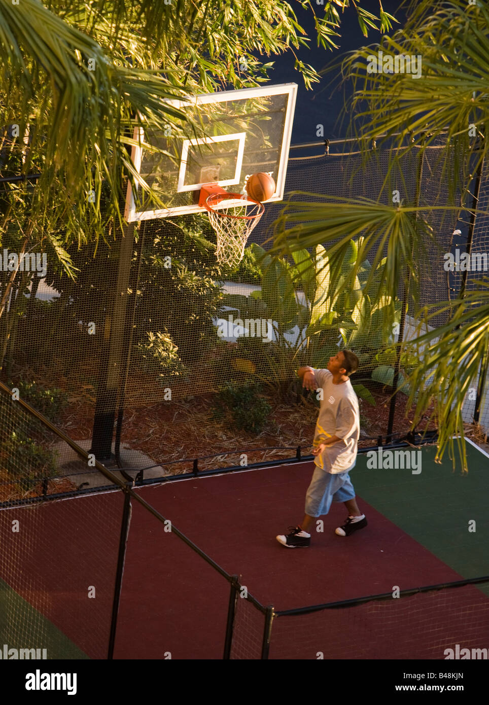 Young man playing basketball on an outdoor court Stock Photo - Alamy