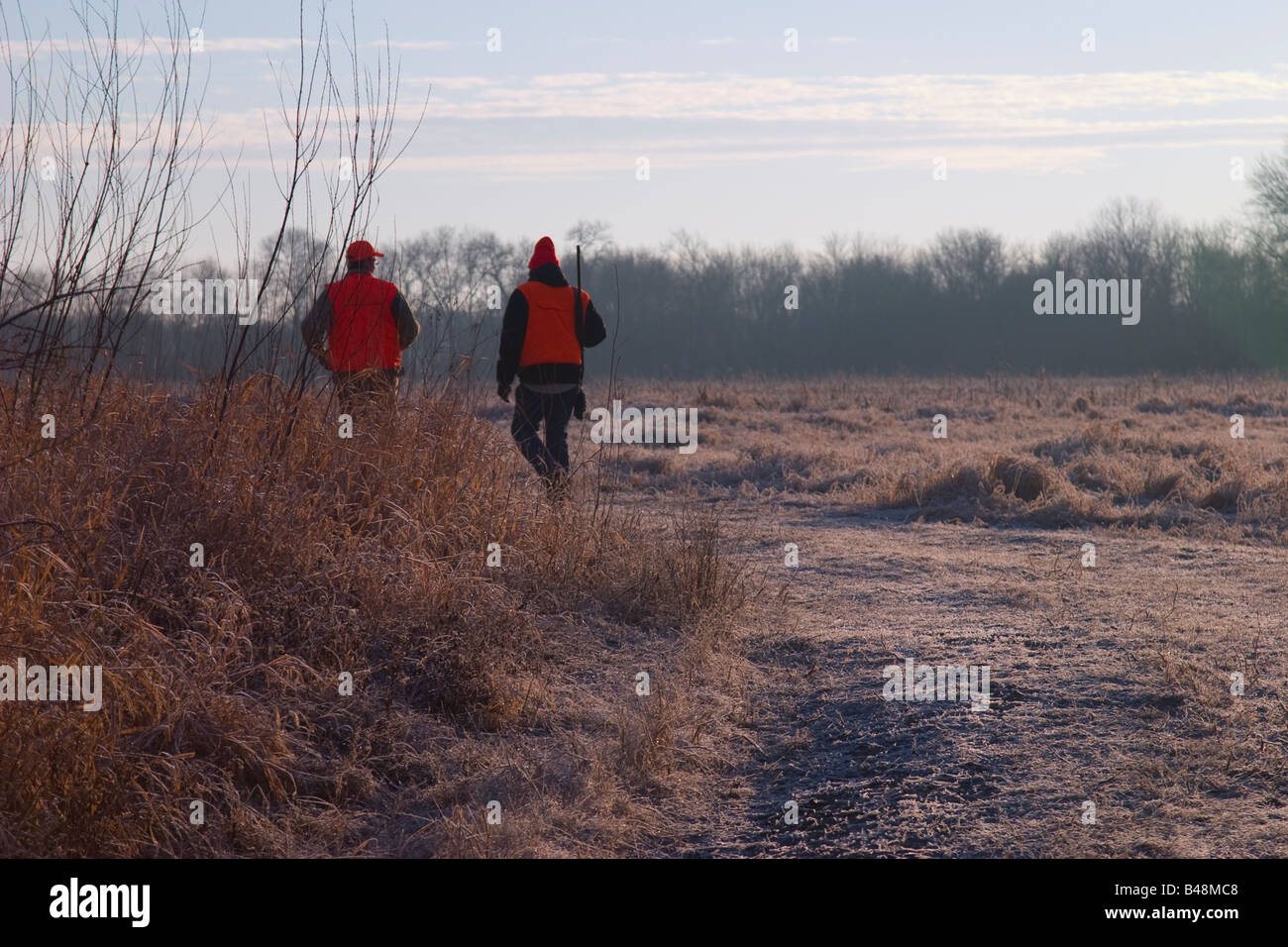 Two hunters in field on wintery morning Stock Photo - Alamy