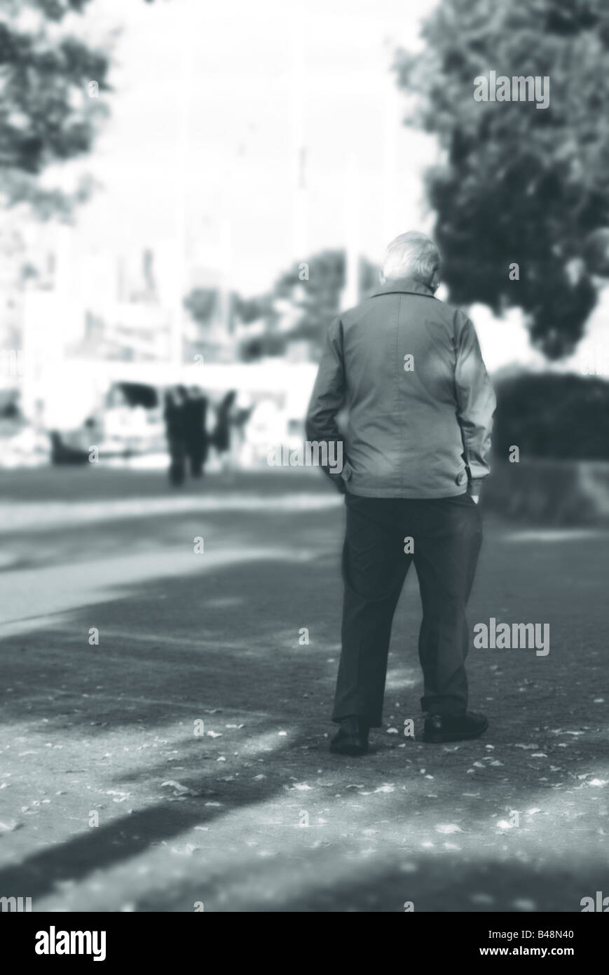 Monotone blue tinted picture of an old man shuffling away into the ...