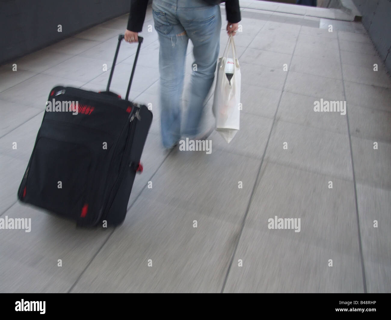 person pulling heavy trolley case in town Stock Photo - Alamy