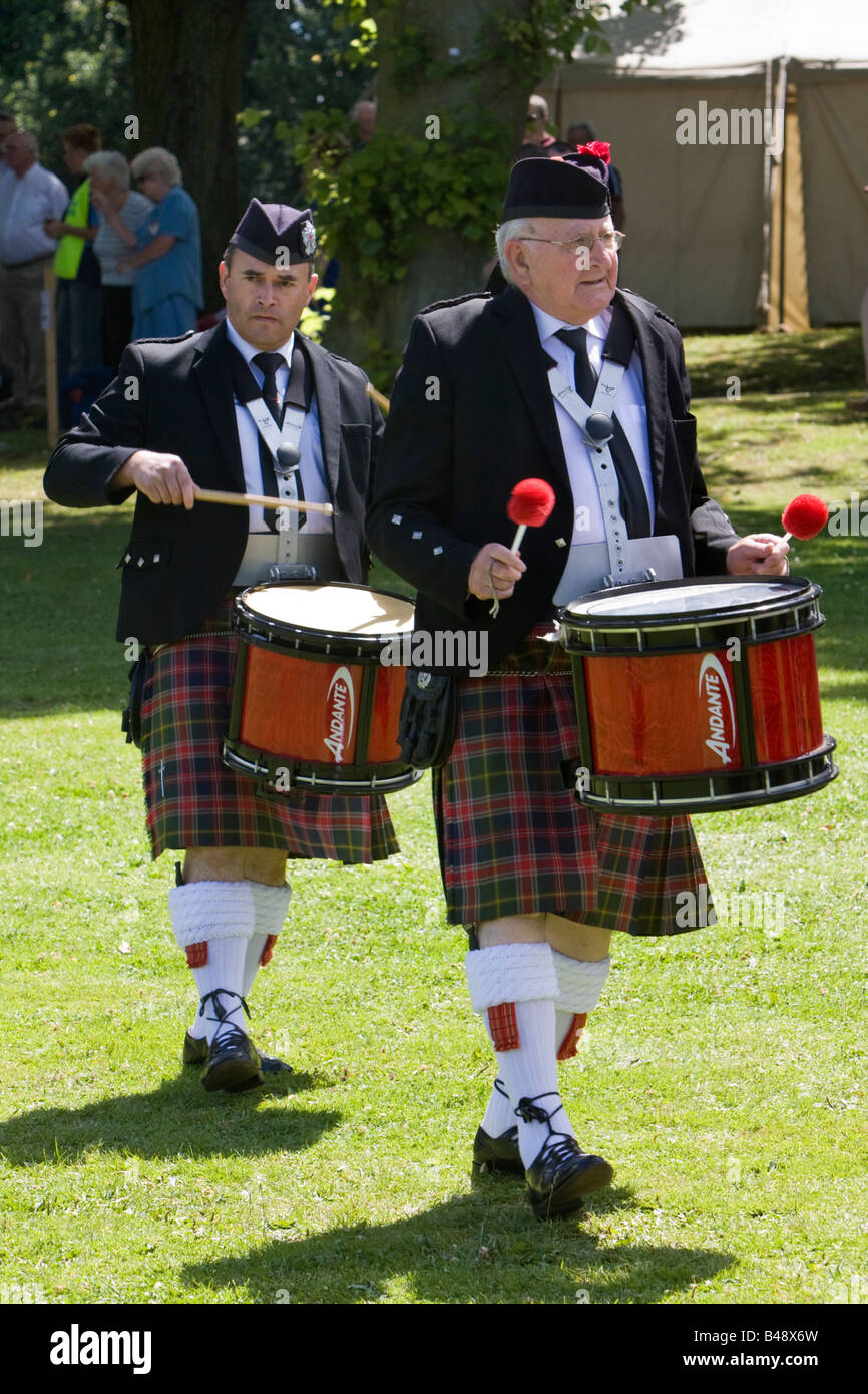 Two members of the British Airways Pipe Band march and play their drums ...