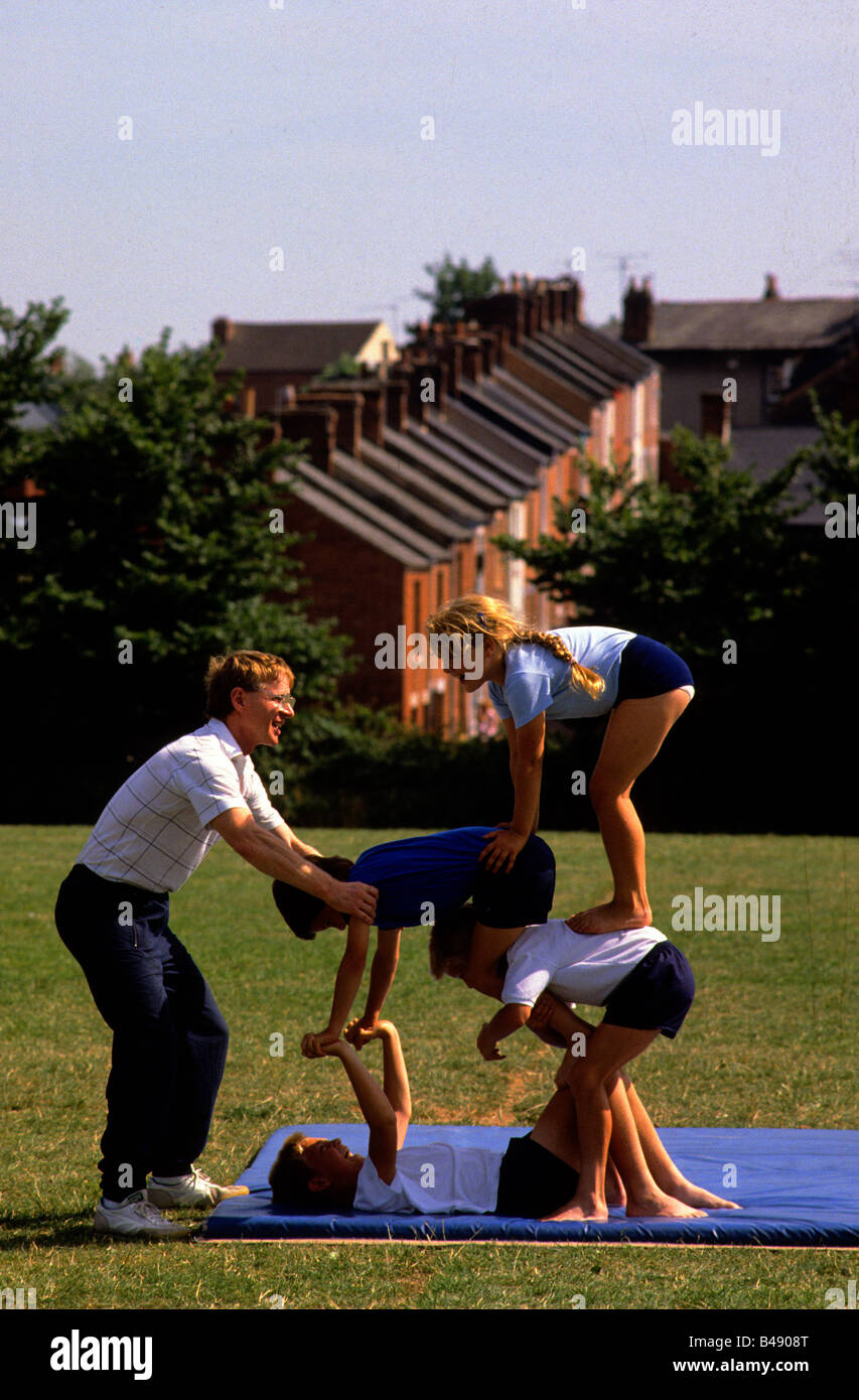 Teacher showing exercise on mat to pupils during gym class in primary ...