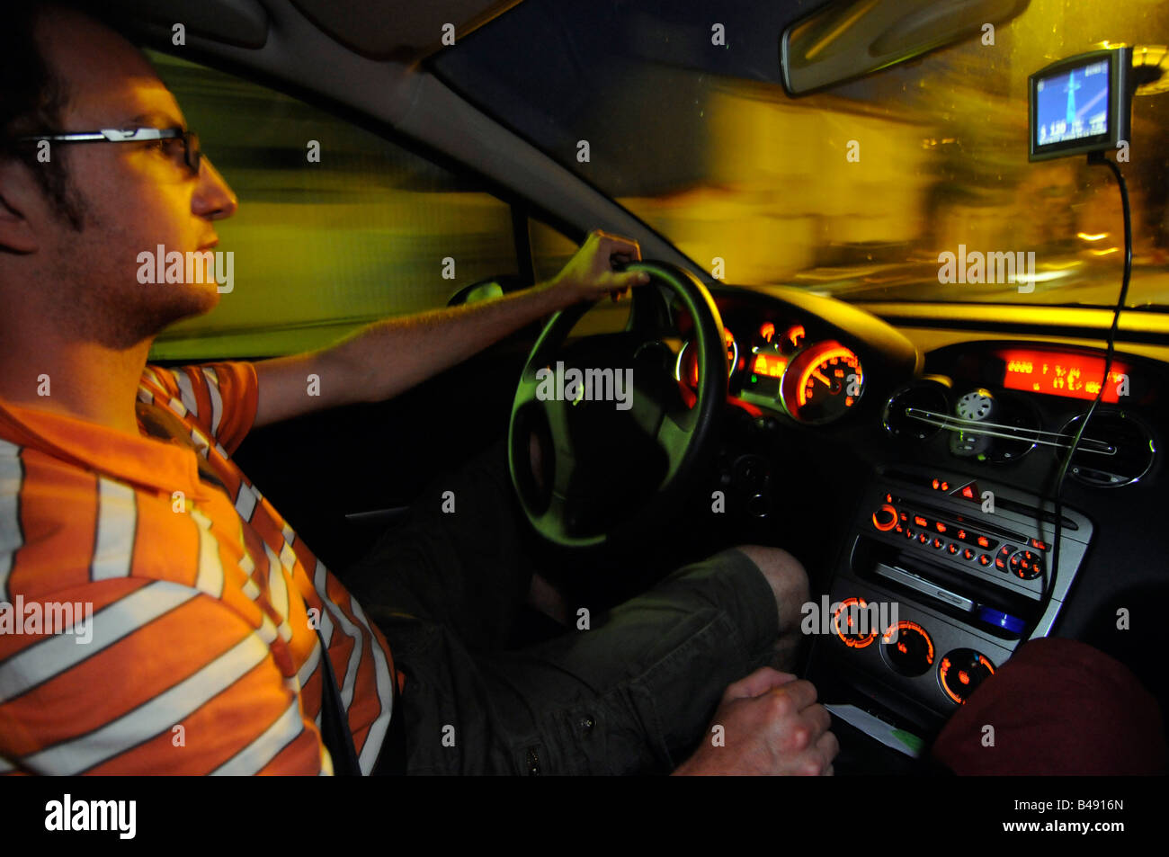 A man driving his car at night with GPS navigation system Stock Photo ...